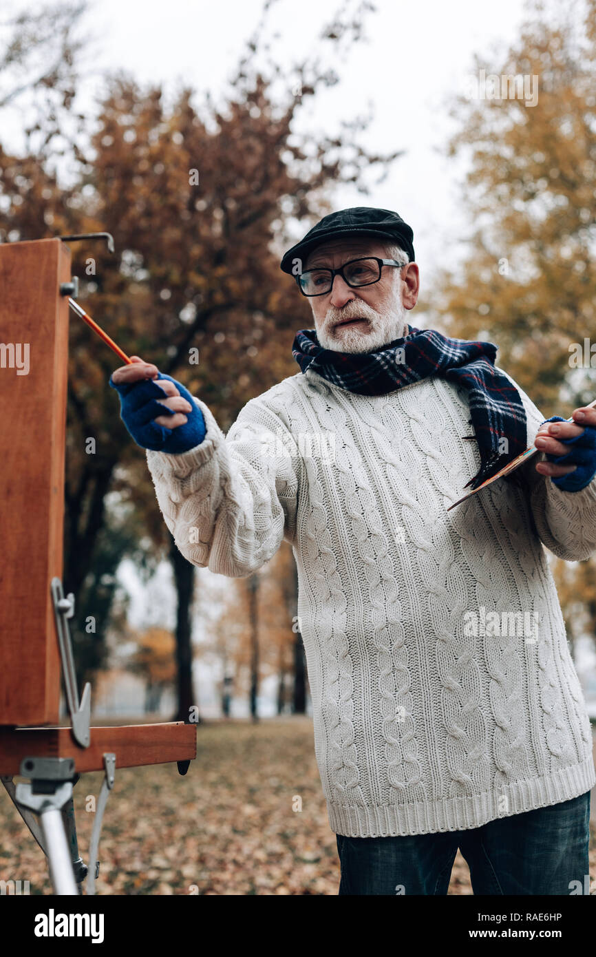 Serious bearded man holding palette in left hand Stock Photo - Alamy