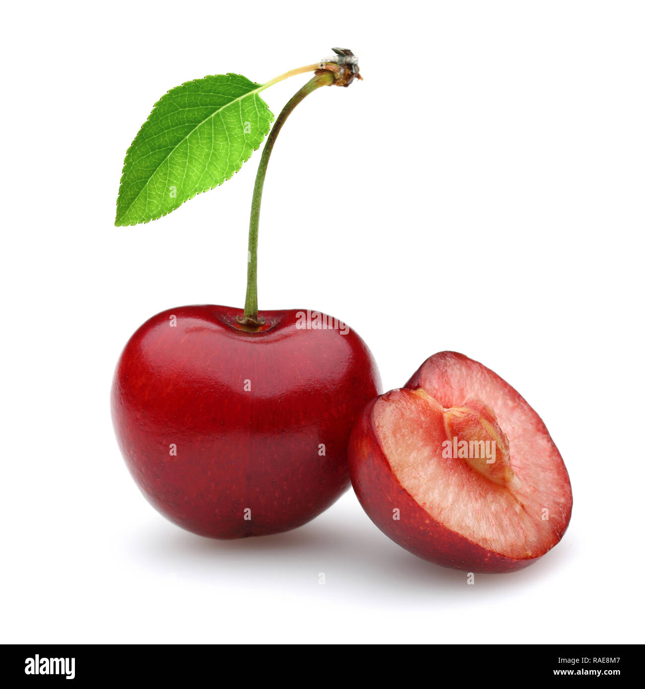 Ripe red cherry with juicy half cherry and leaf isolated on white ...