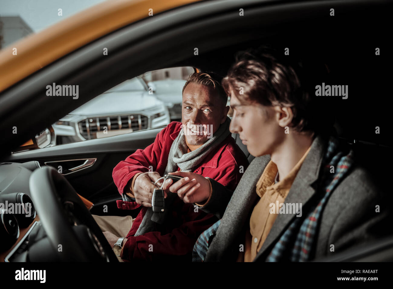 Generous father feeling excited presenting car keys to his son Stock ...
