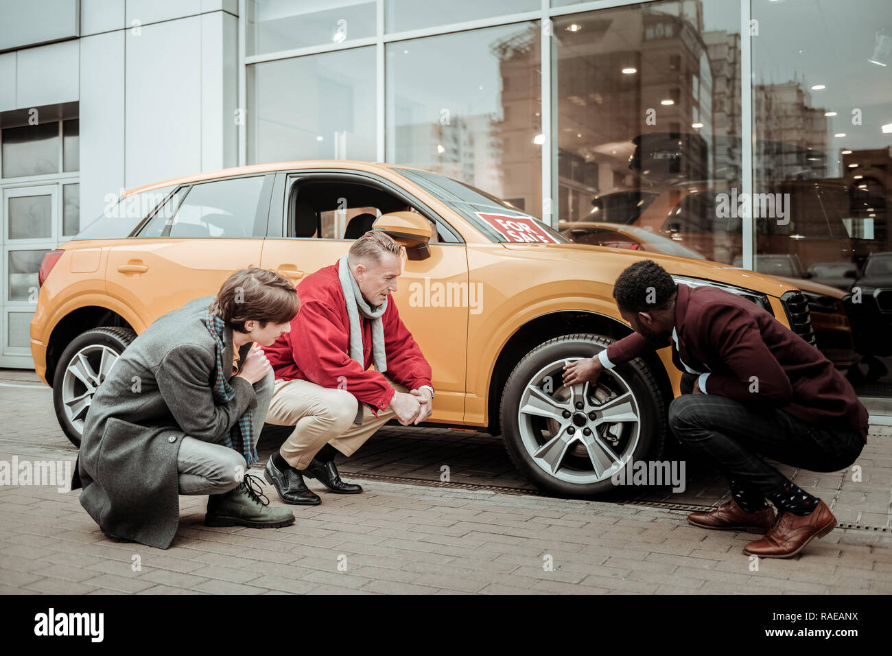 African-American sales manager telling his clients about the wheels ...