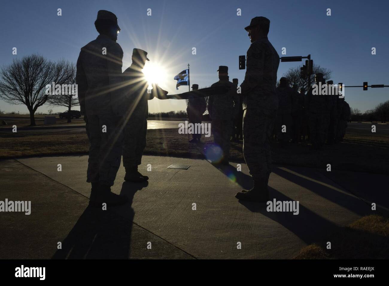 A three-person detail folds the American flag during a formal retreat ...