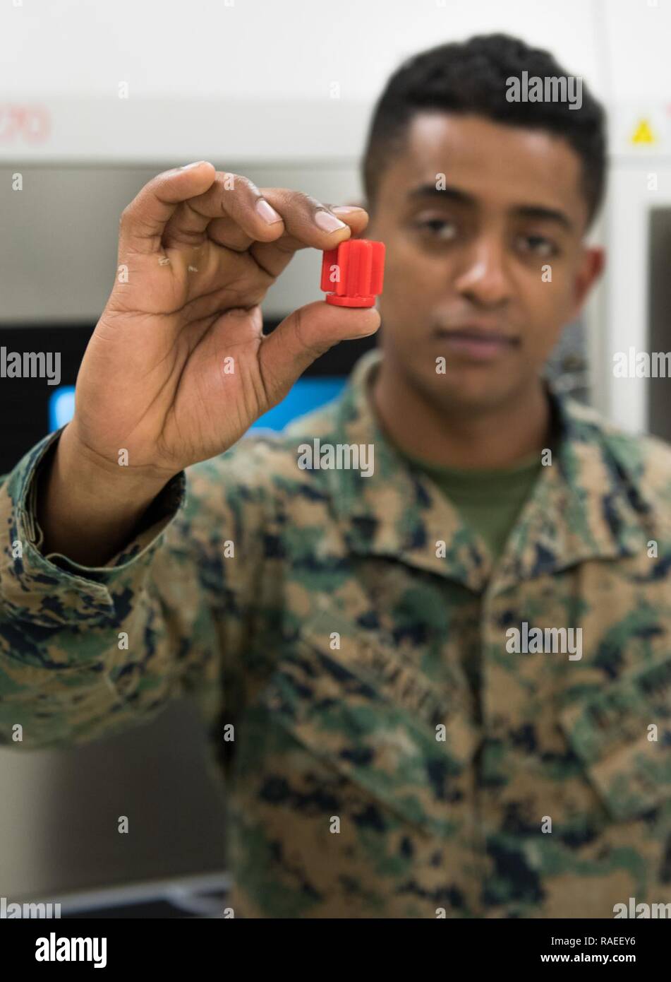 Marine Corps Cpl. Habtamu Sharew displays a 3-D printed part made ...