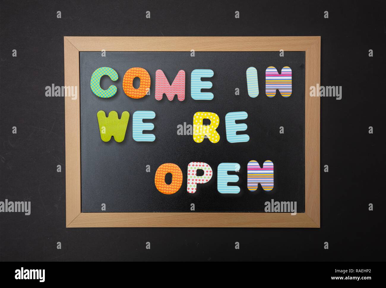 Open, come in. Board with black frame, text Come in, we re open in ...