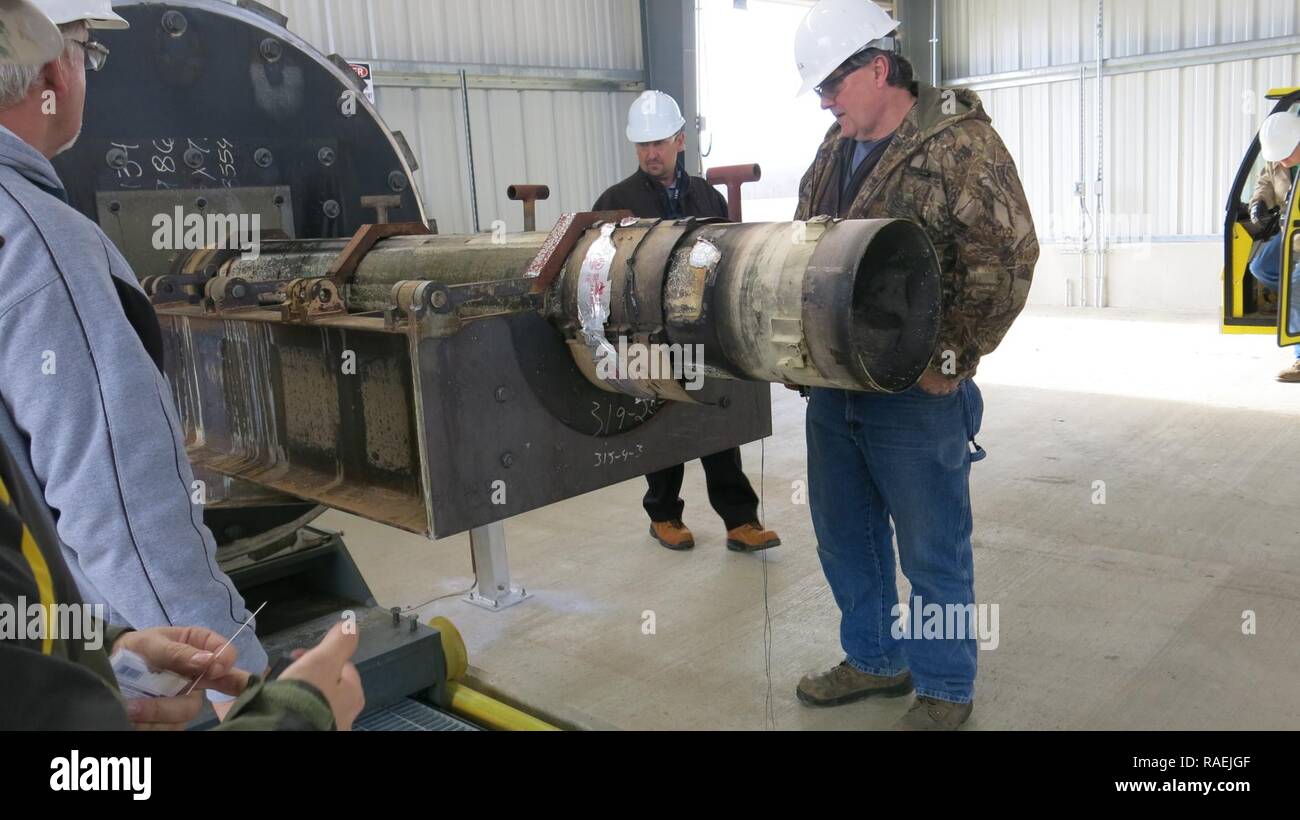 Technicians inspect a fired rocket motor at the Ammonium Perchlorate ...