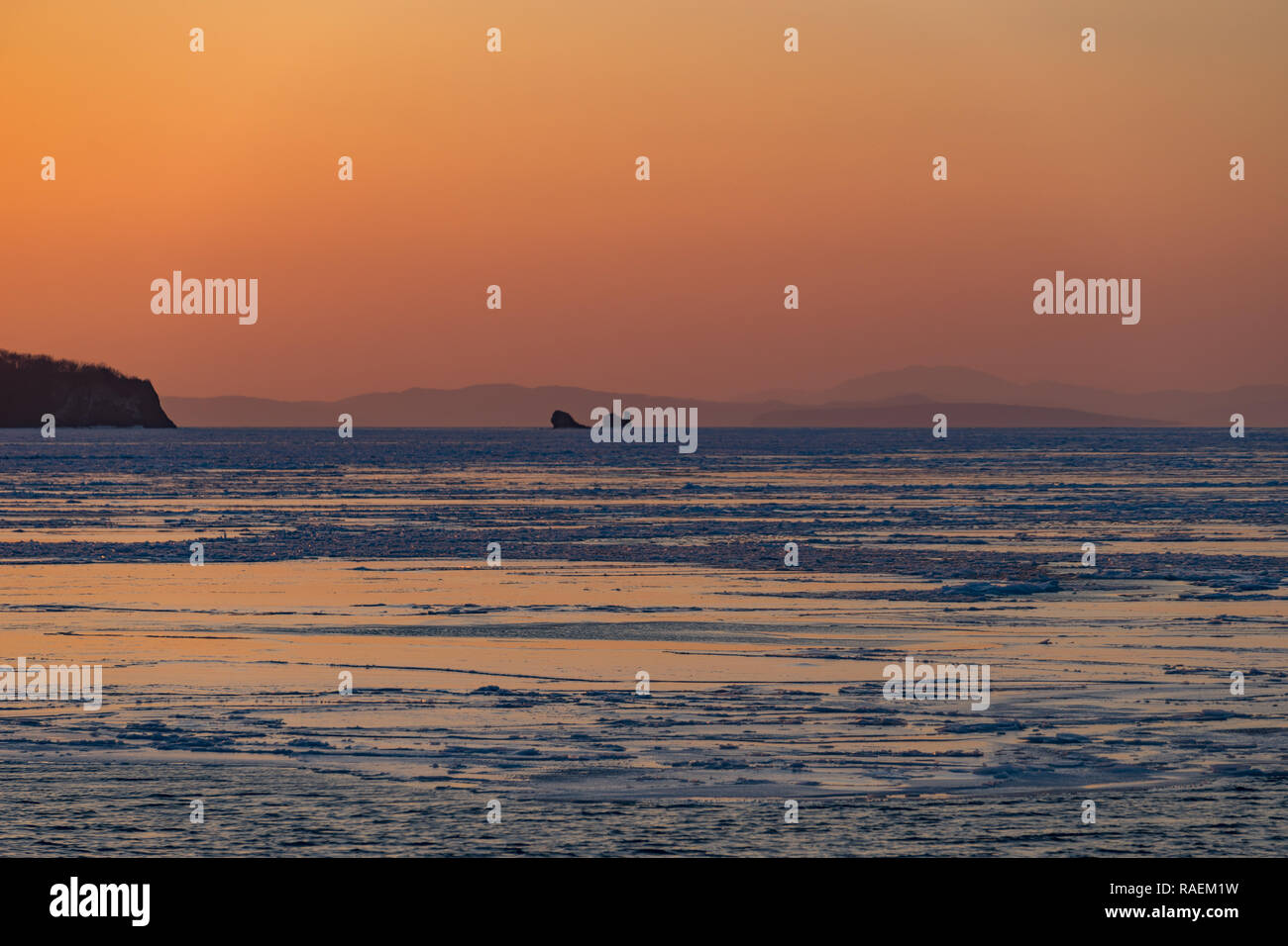 Winter seascape with ice floes on the water surface at sunset. Beauty ...