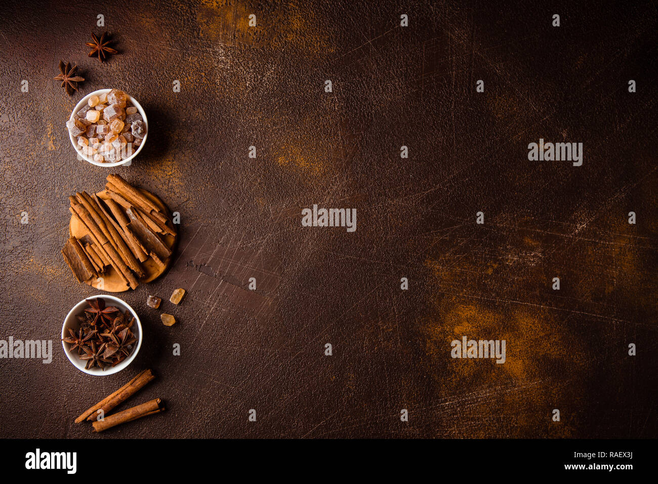 Cinnamon sticks, anise sprouts and caramelized sugar on a dark ...