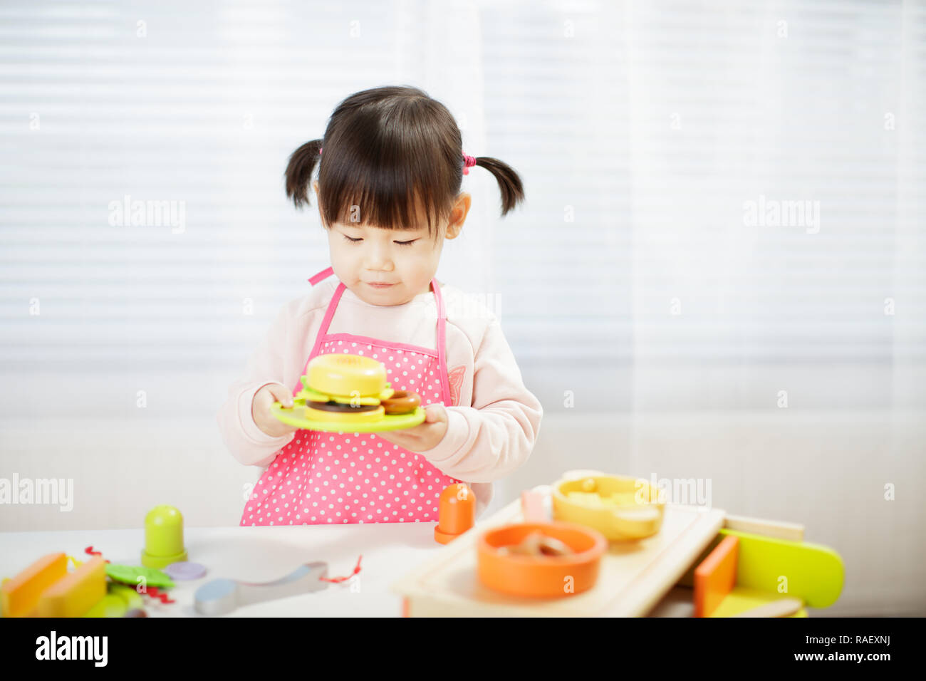 toddler baby girl pretend play food preparing Stock Photo - Alamy