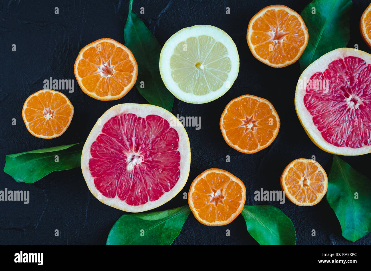 Mixed citrus background. Assorted fresh citrus fruits with leaves on ...