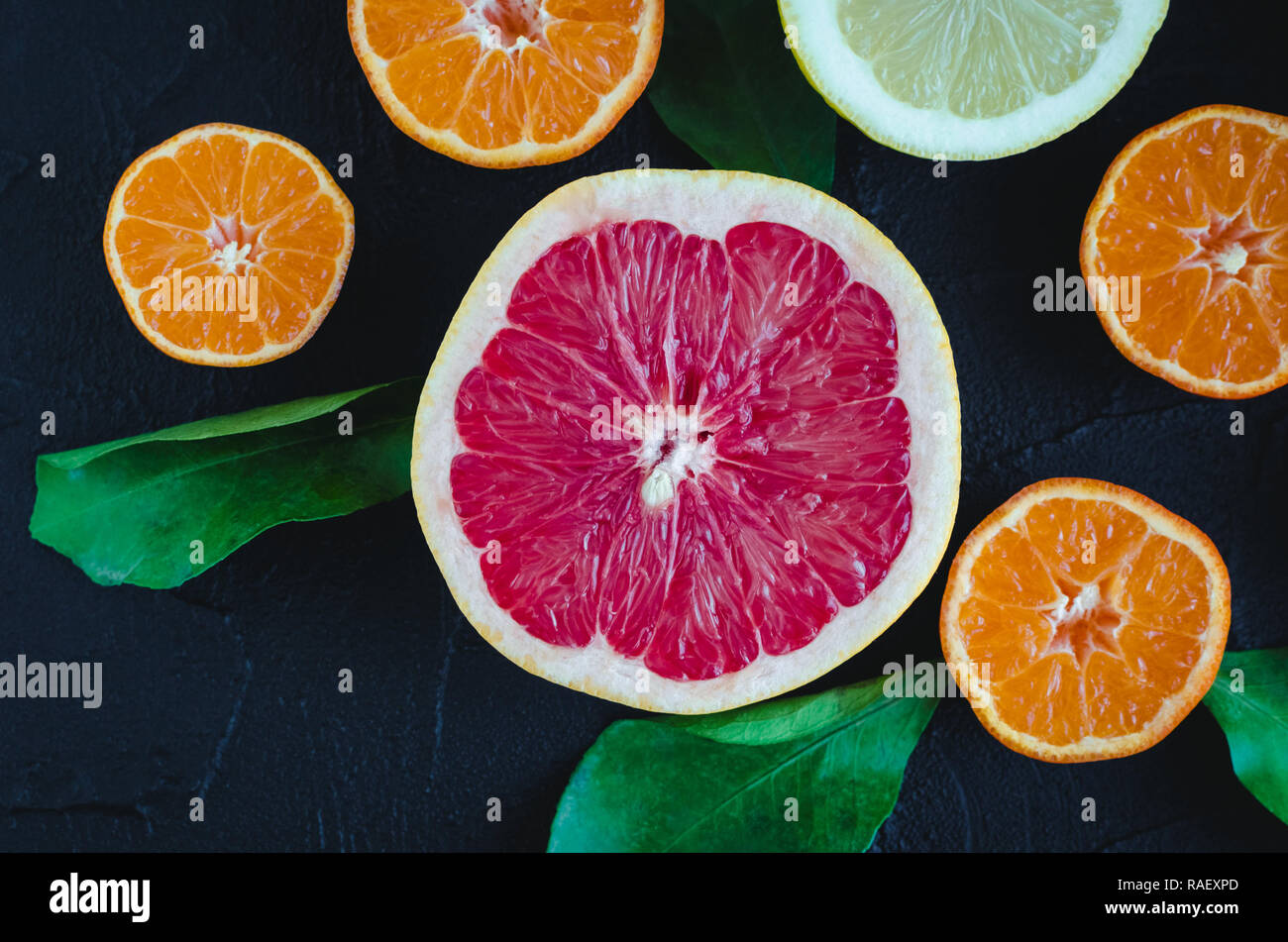 Mixed citrus background. Assorted fresh citrus fruits with leaves on ...