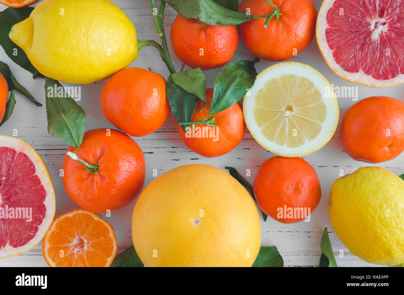 Mixed citrus background. Assorted fresh citrus fruits with leaves on ...