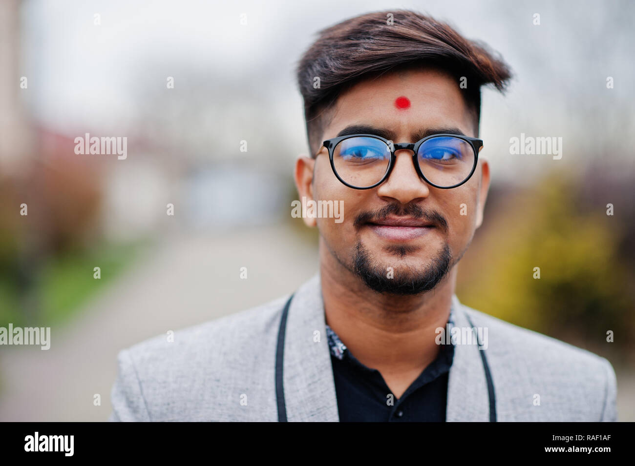 Close up head of stylish indian man with bindi on forehead and glasses ...