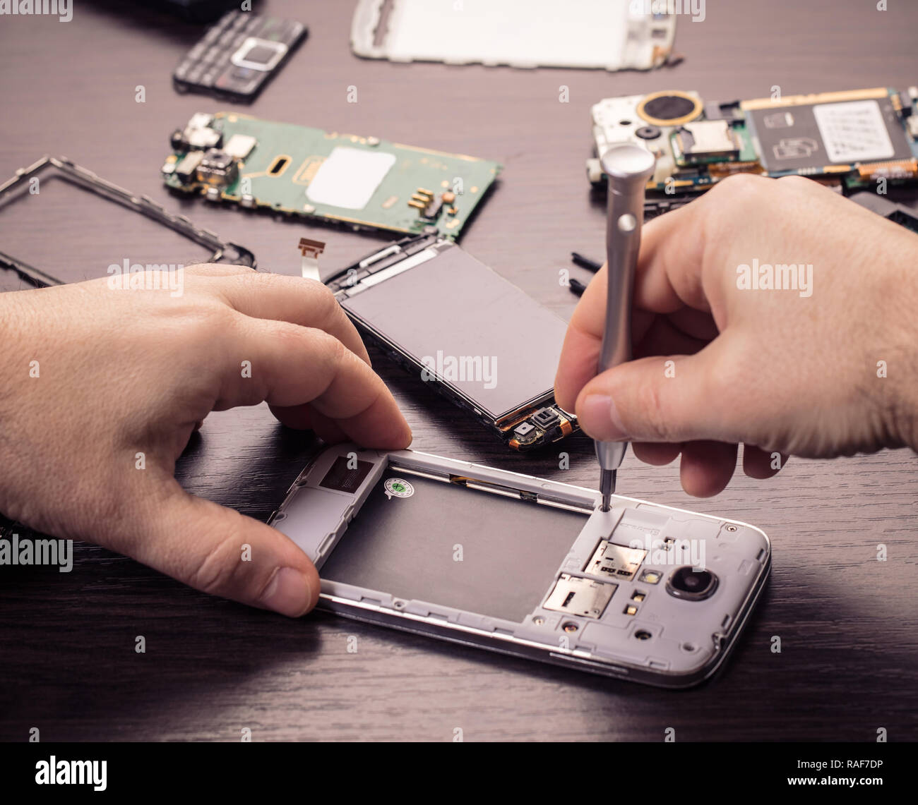 mobile phone repair, hands closeup on a wooden table Stock Photo - Alamy