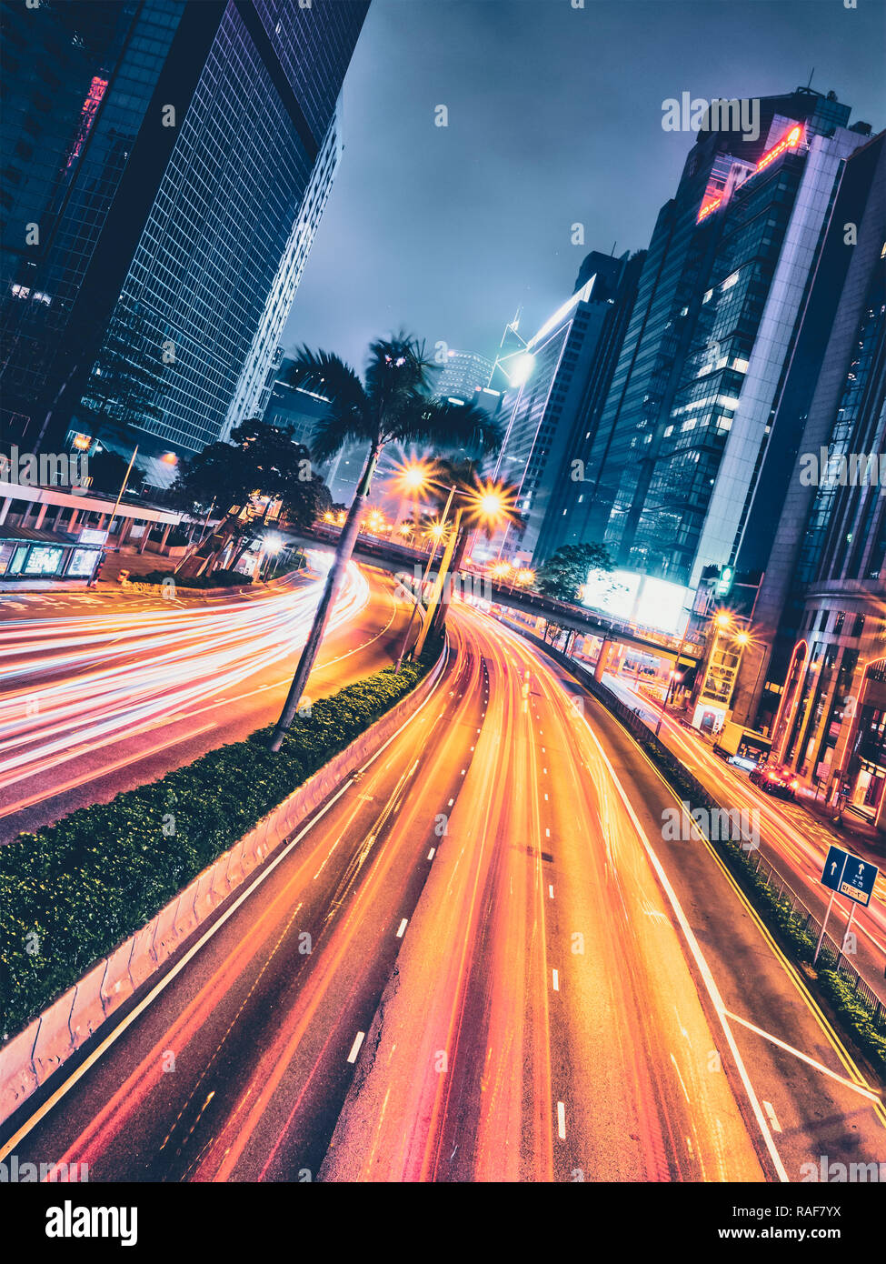 Street traffic in Hong Kong at night. Office skyscraper buildings and ...