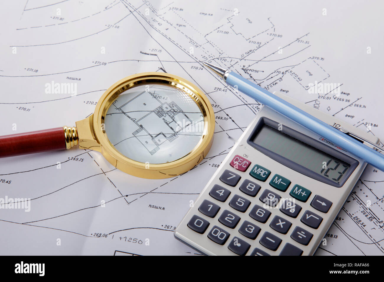Blueprints, pencil, square drawing, magnifier and calculator against a ...