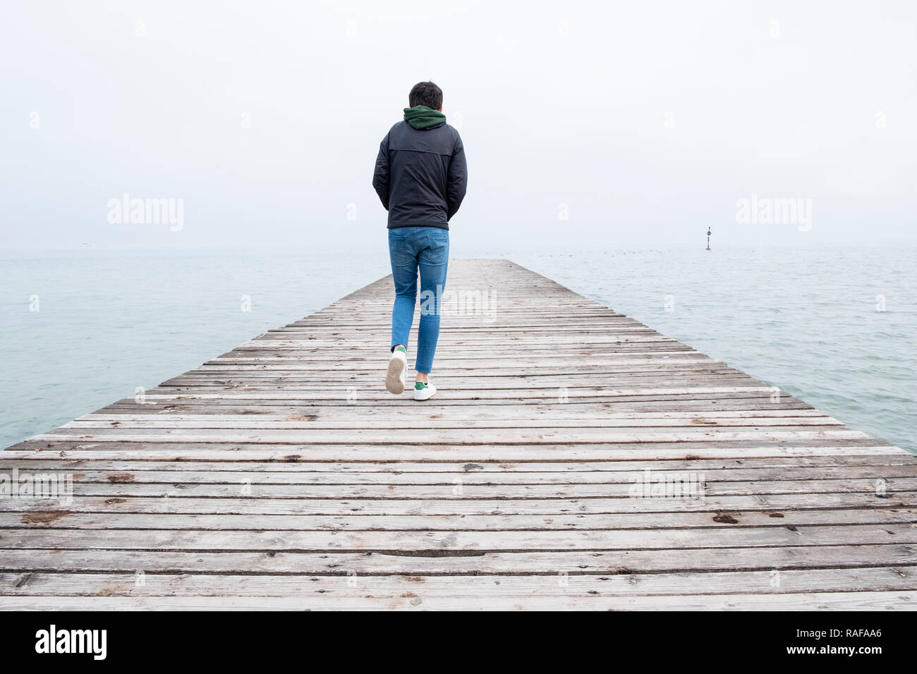 young boy walks on the pier Stock Photo - Alamy