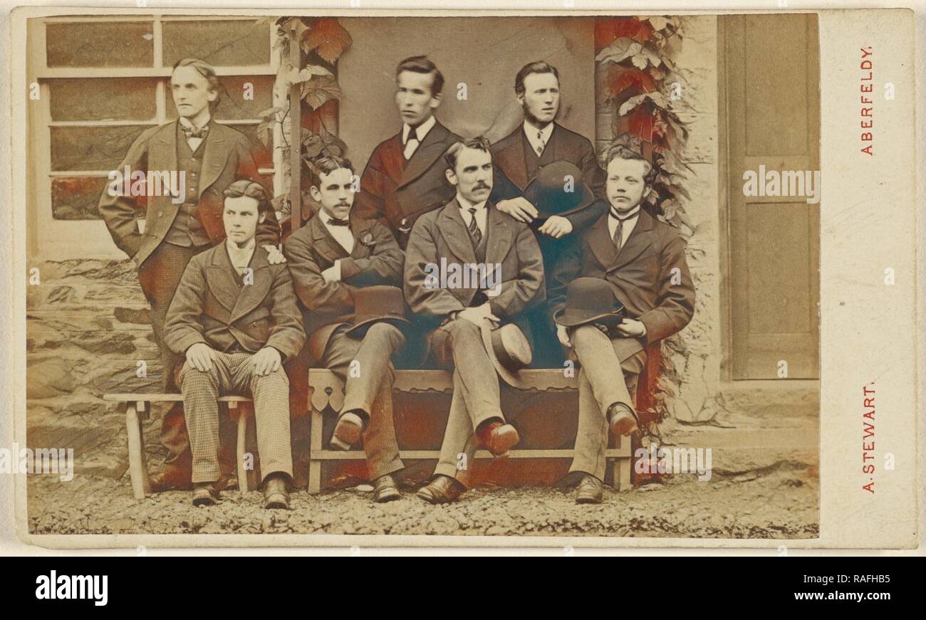 Group of seven men: four seated, three standing, some holding hats, A ...