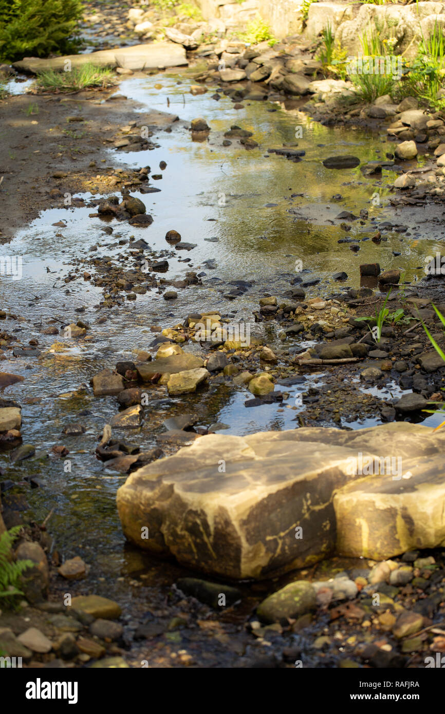 Shallow stream with large boulders and small rocks and pebbles Stock ...