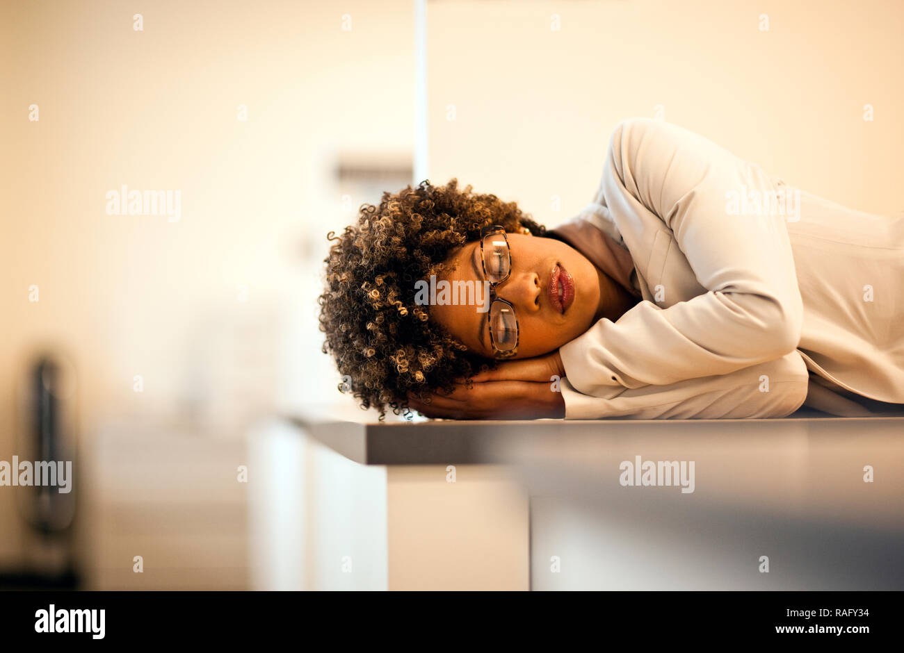 Businesswoman takes a nap on an office desk Stock Photo - Alamy