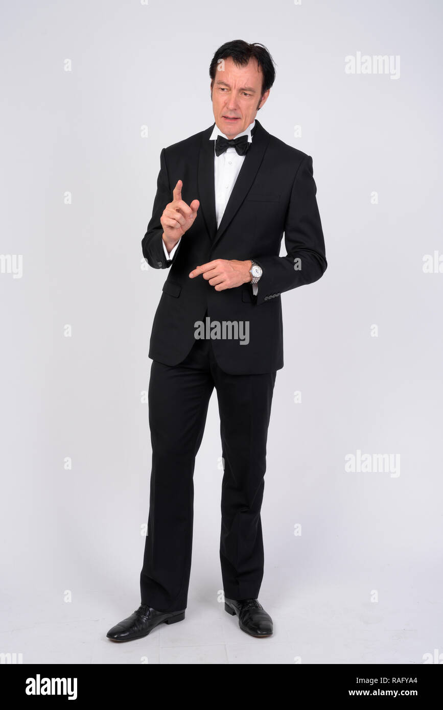 Full body shot of mature handsome businessman thinking and talking ...