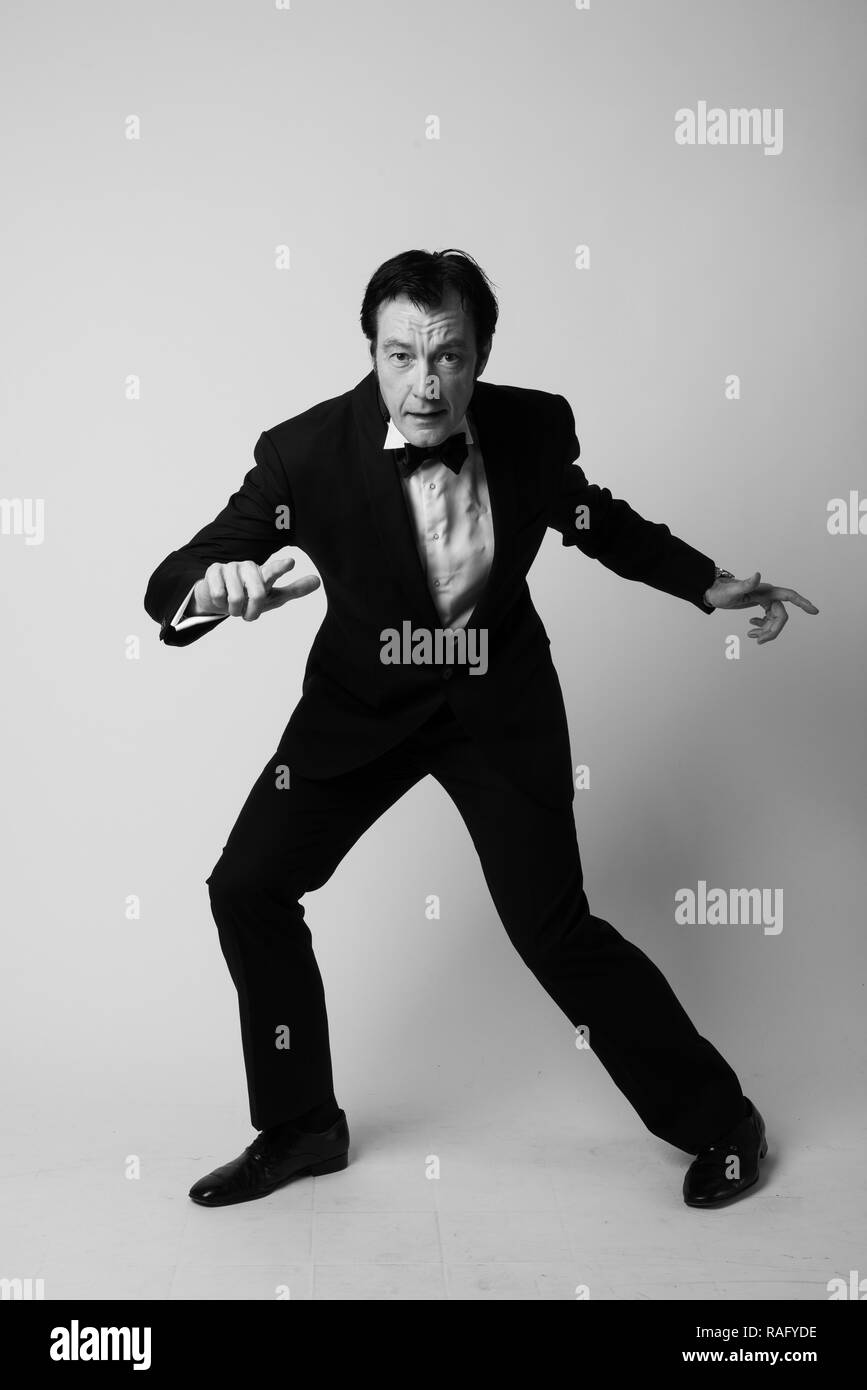 Full body shot of mature handsome businessman as secret agent in black ...