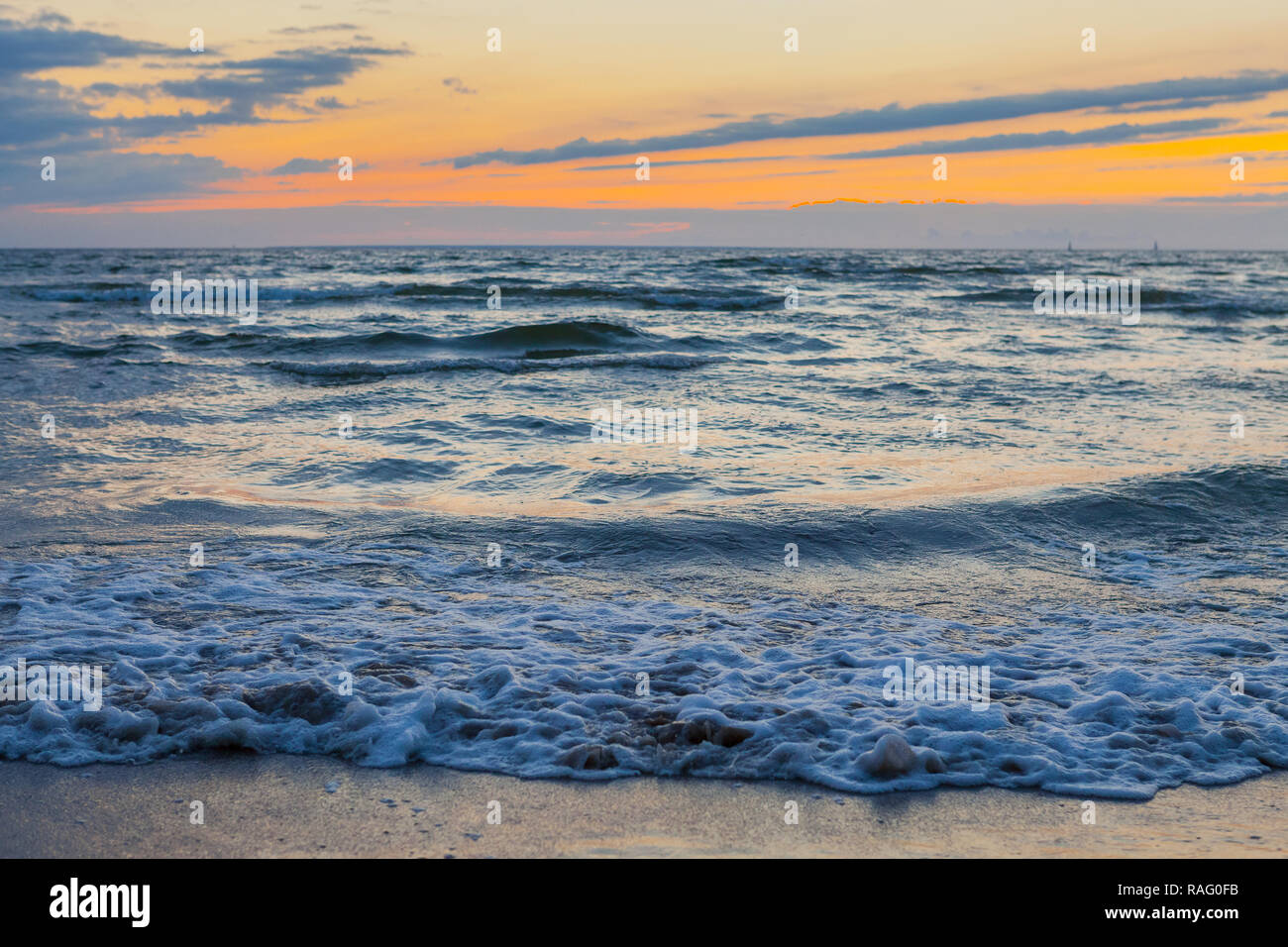 Low waves on Baltic sea at sunset. Cosy flat sandy beach Stock Photo ...