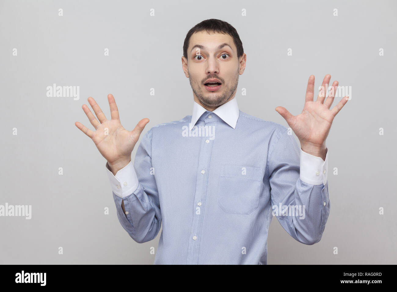 Portrait of shocked handsome bristle businessman in classic blue shirt ...