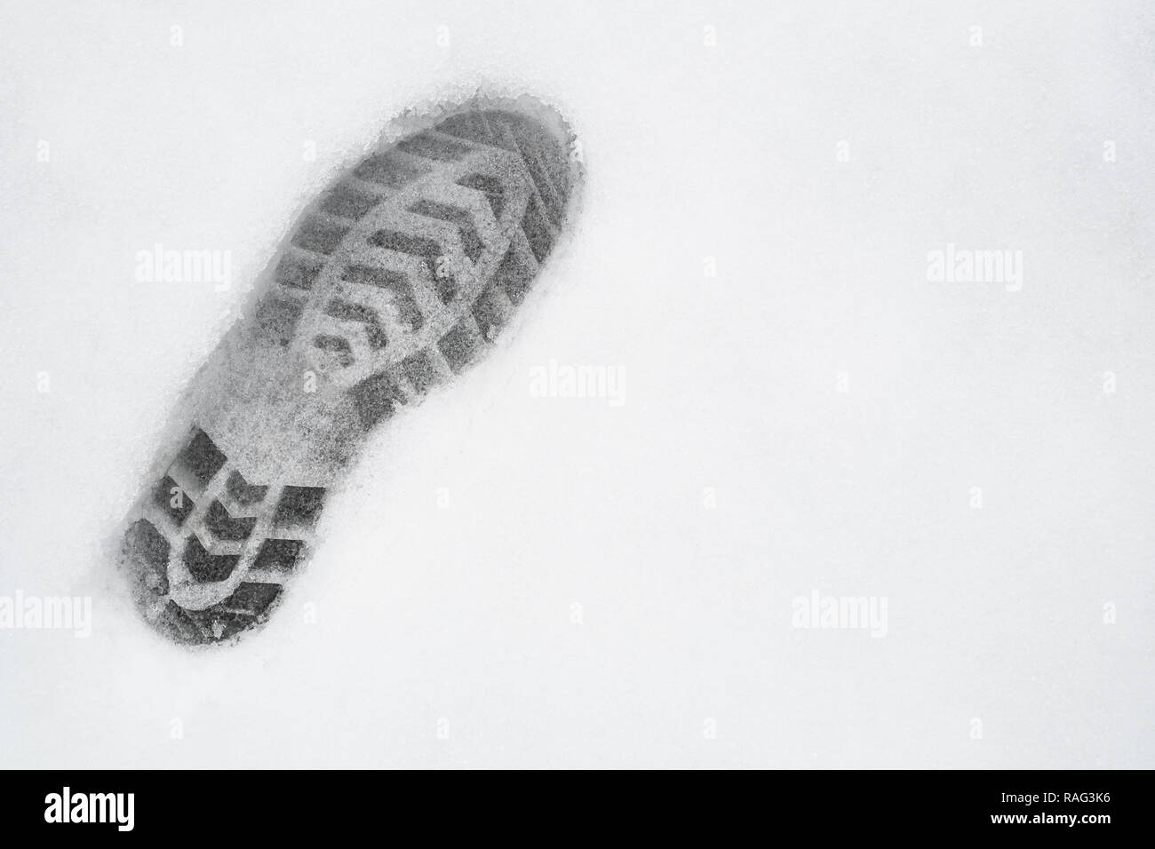 one left foot shoe print on snow, top view, copy space, cloudy, no ...