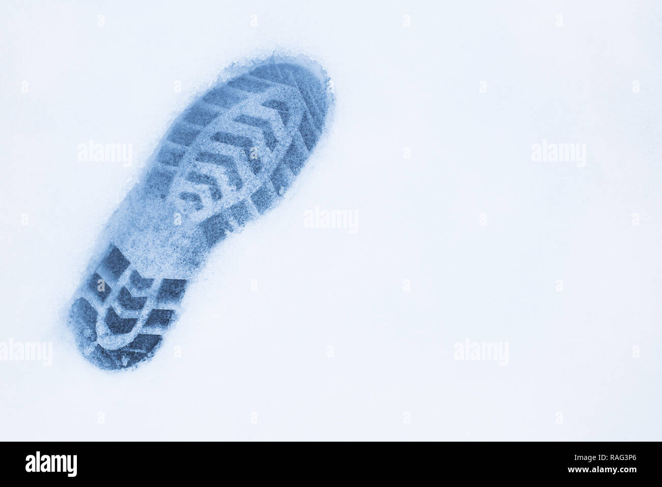 one left foot shoe print on snow, top view, copy space, cloudy and ...