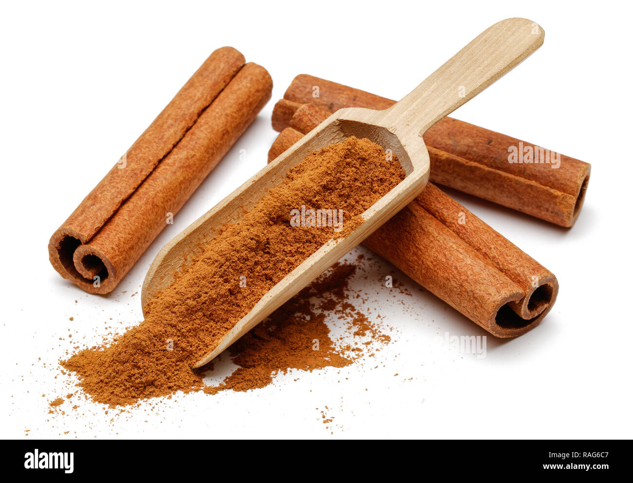 Cinnamon sticks with powder and wooden scoop isolated on white ...