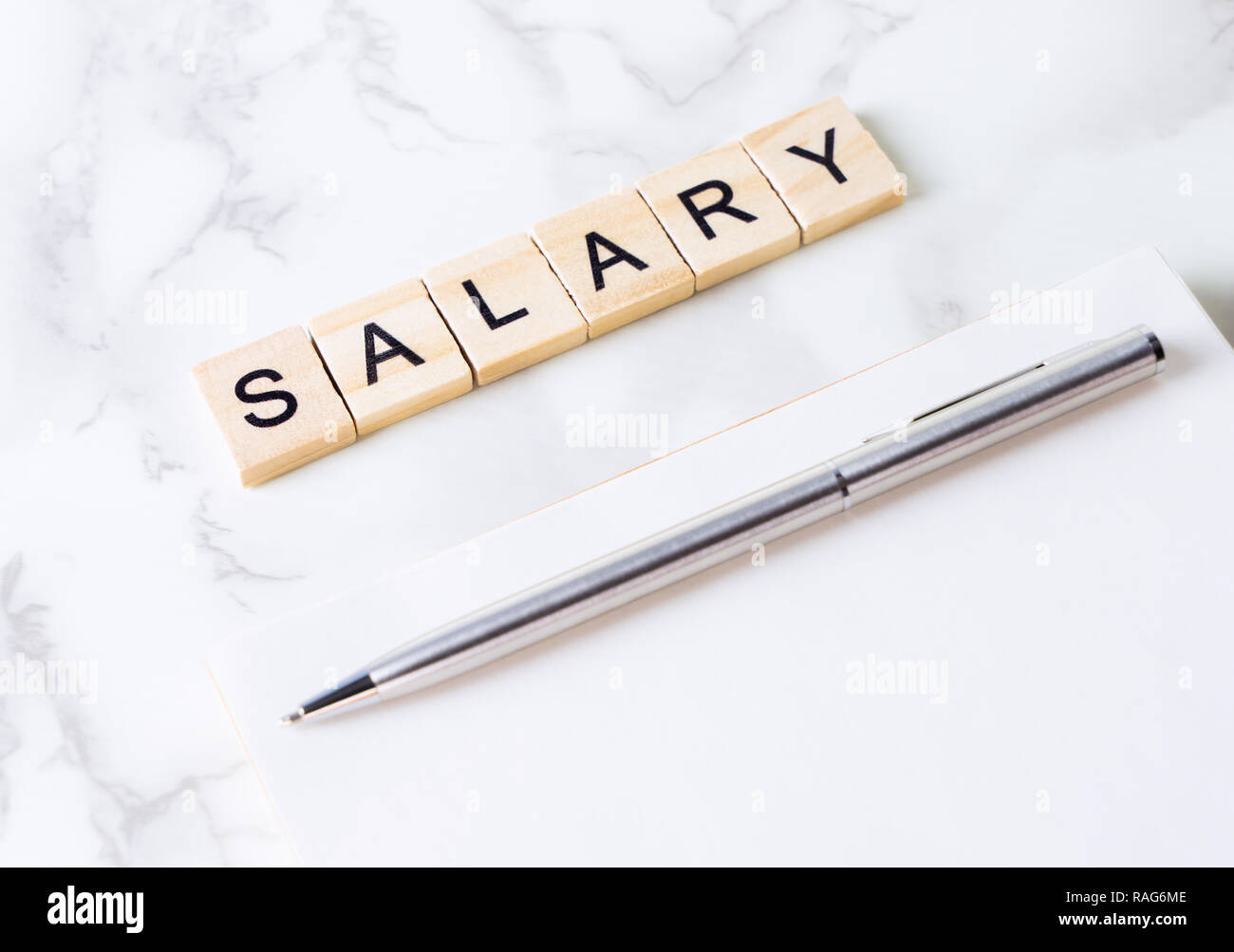 Salary text on office notebook with pen Stock Photo - Alamy