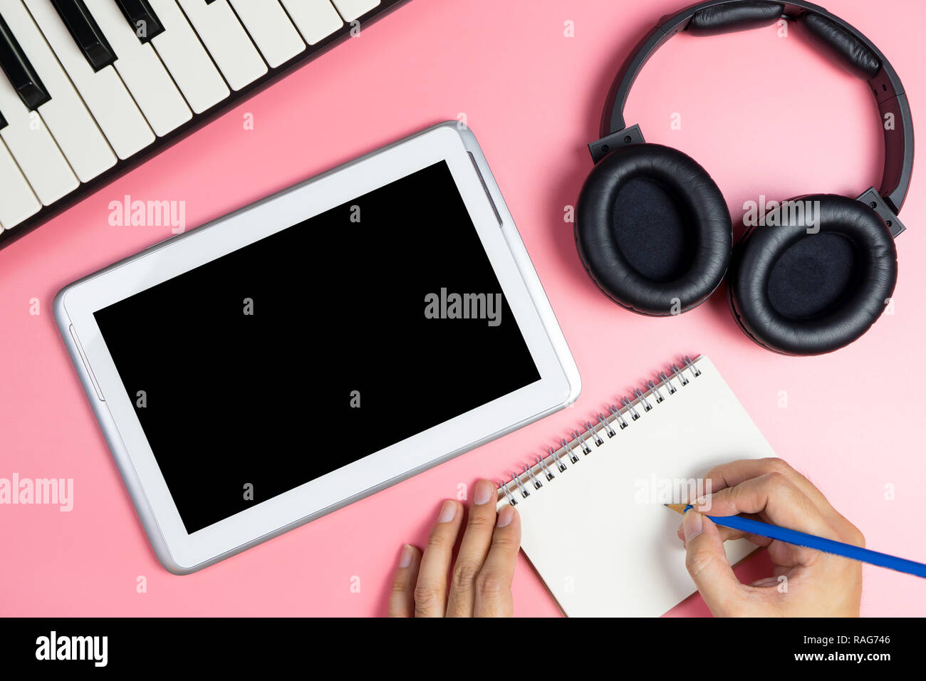 Music Songwriter is writing on a notebook with blank tablet screen for ...