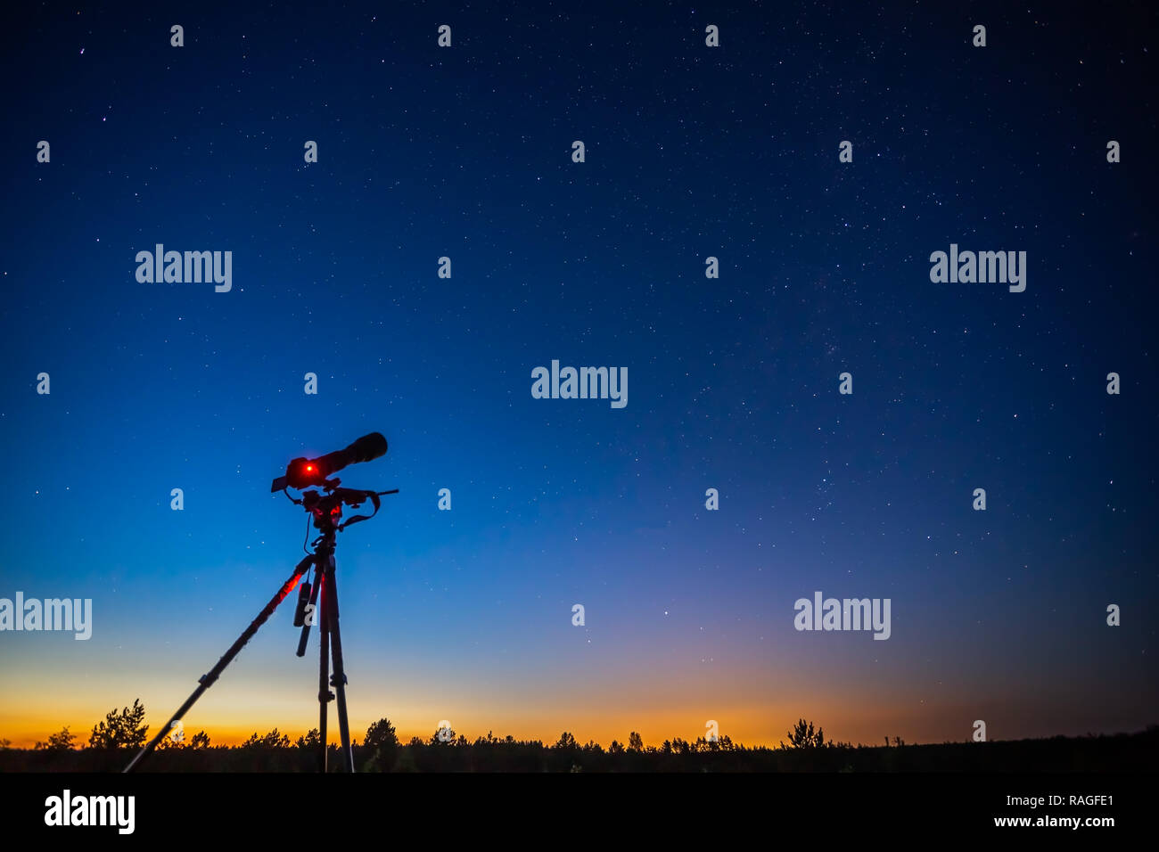 Tripod and a photo camera under starry sky Stock Photo - Alamy