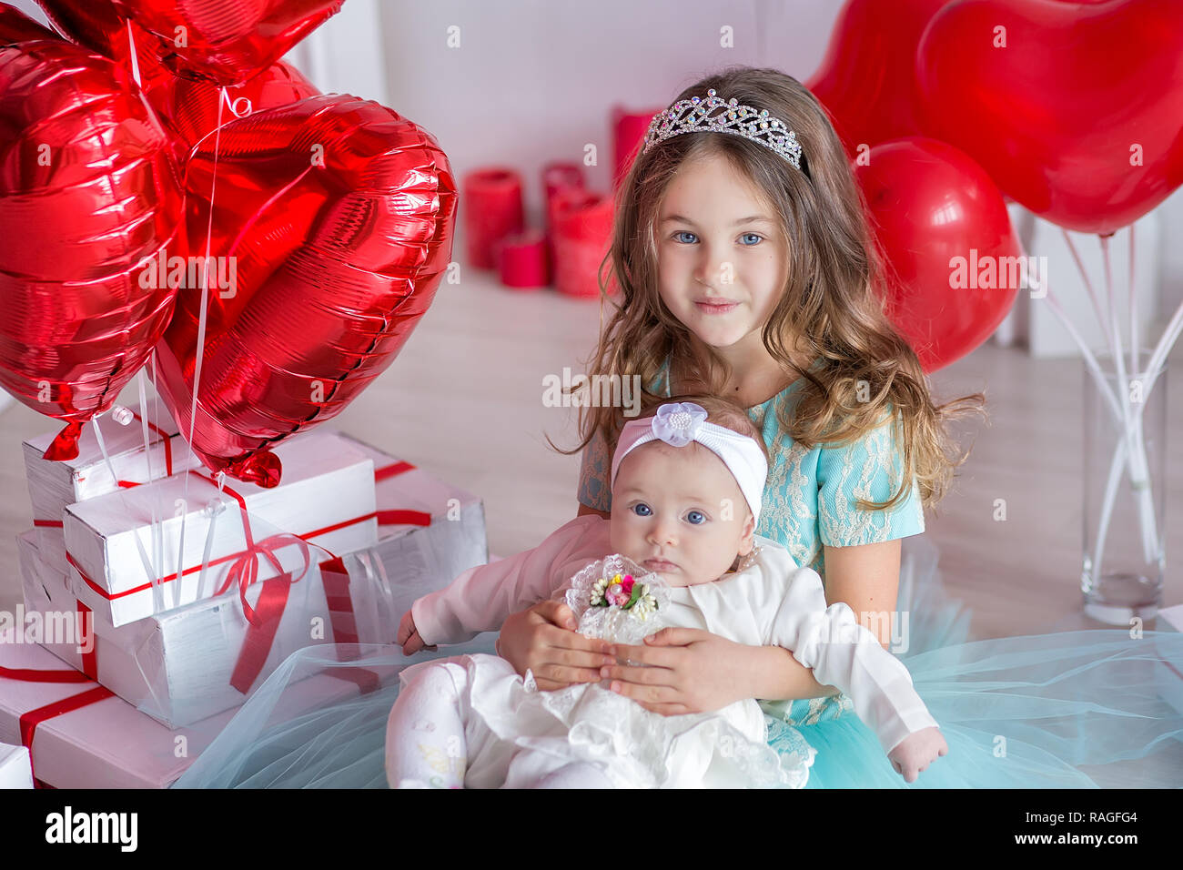 Cute baby girl celebrating birth day together close to red balloons ...