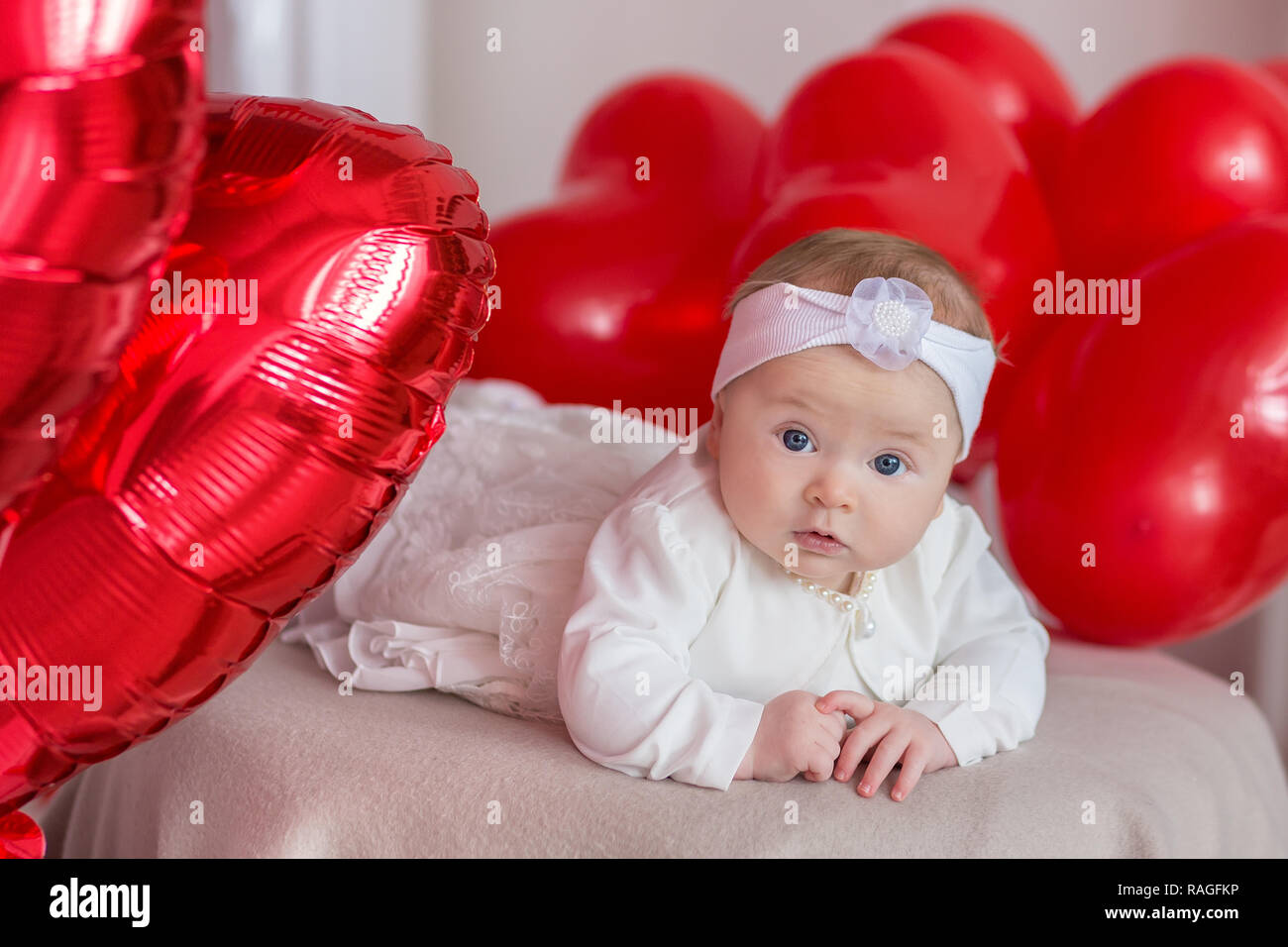 Cute baby girl celebrating birth day together close to red balloons ...