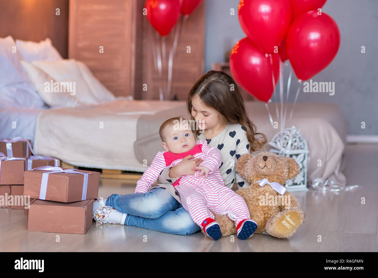 Cute baby girl celebrating birth day together close to red balloons ...