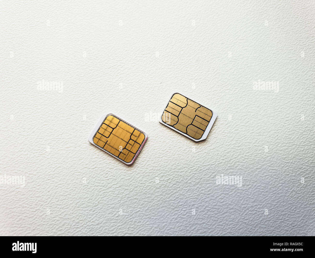 two micro sim cards on a light background surface Stock Photo - Alamy