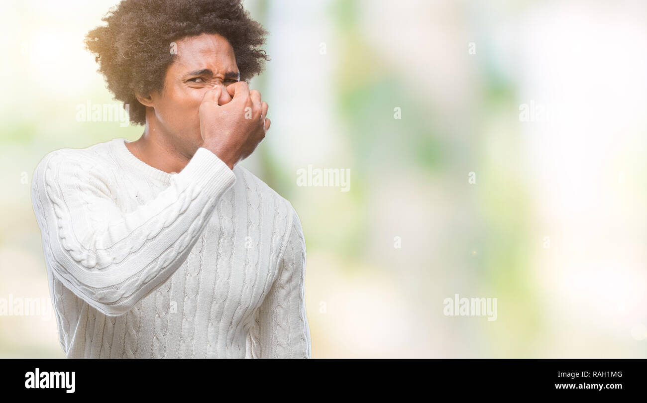 Afro american man over isolated background smelling something stinky ...