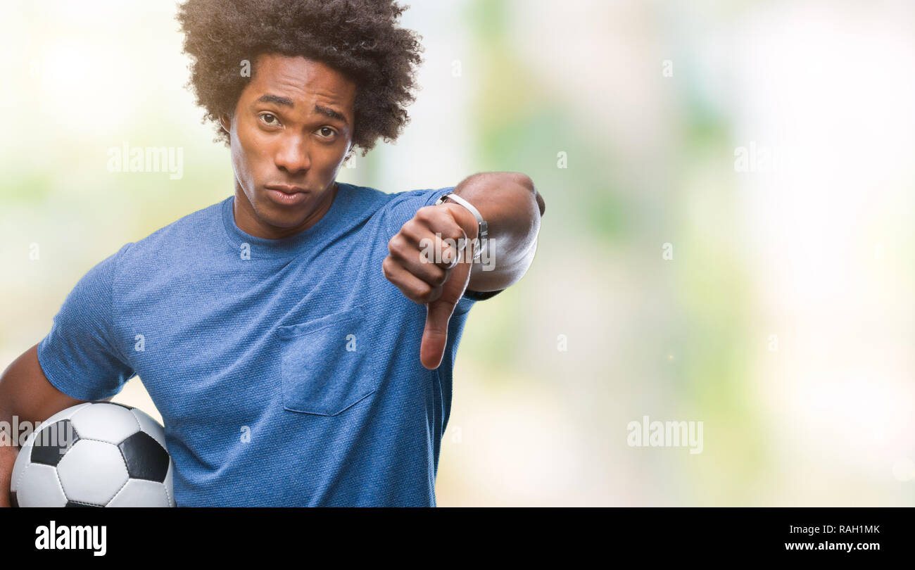 Afro american man holding football ball over isolated background with ...