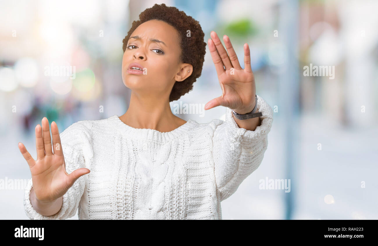 Beautiful young african american woman wearing sweater over isolated ...