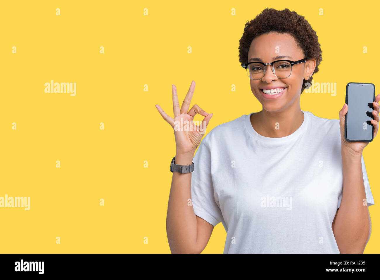 Young african american woman showing smartphone screen over isolated ...