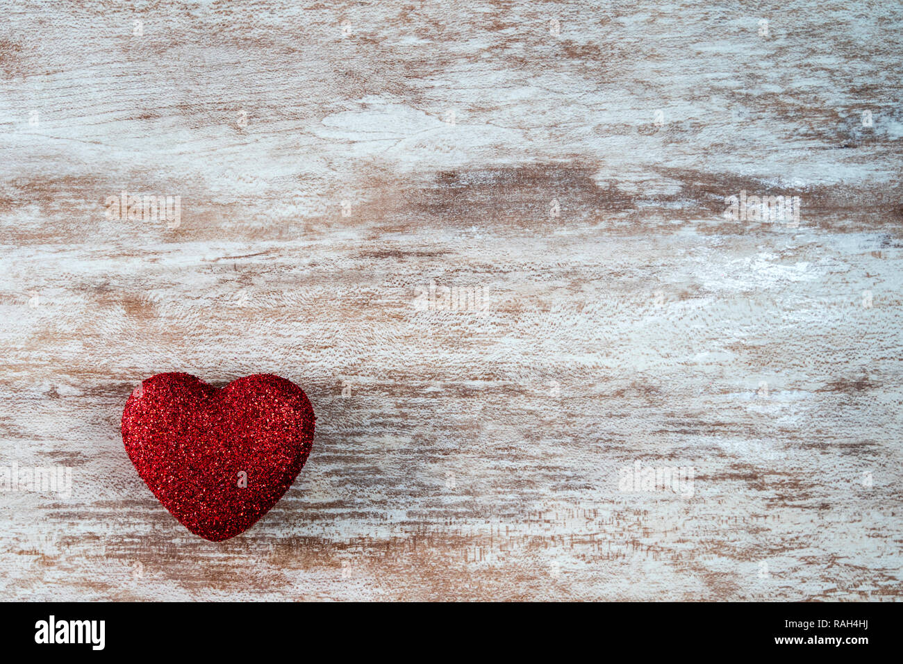 Red heart with glitter on the bottom of a cozy wooden background love ...