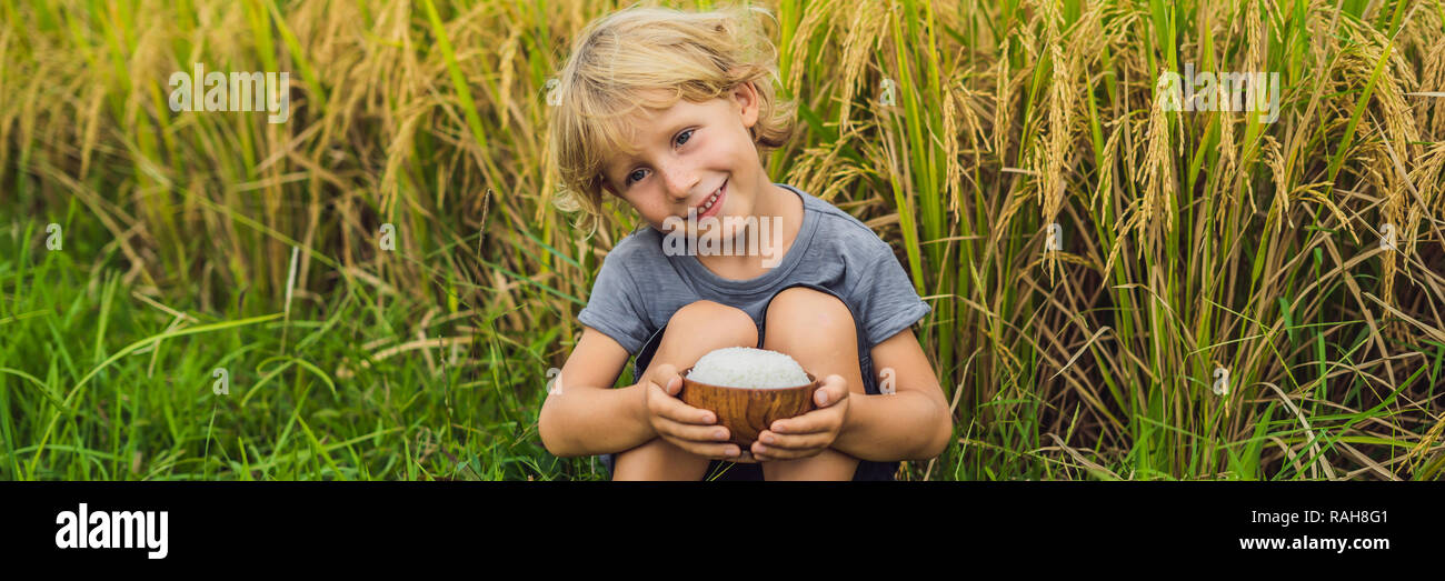 Boy is holding a cup of boiled rice in a wooden cup on the background ...