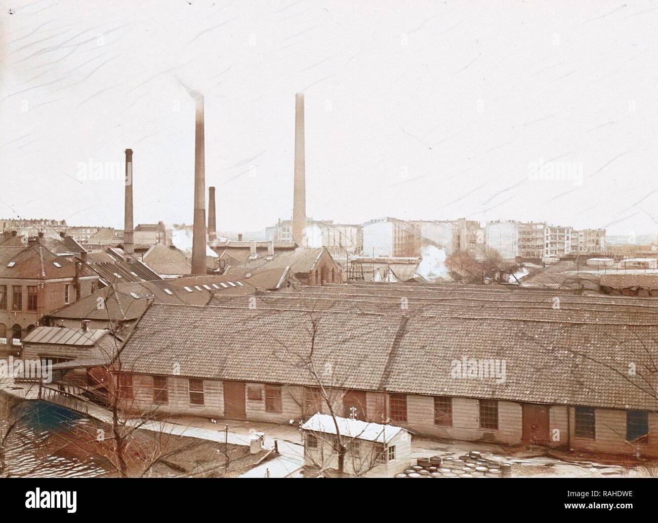 Exterior of factory buildings with chimneys, in the foreground wooden ...