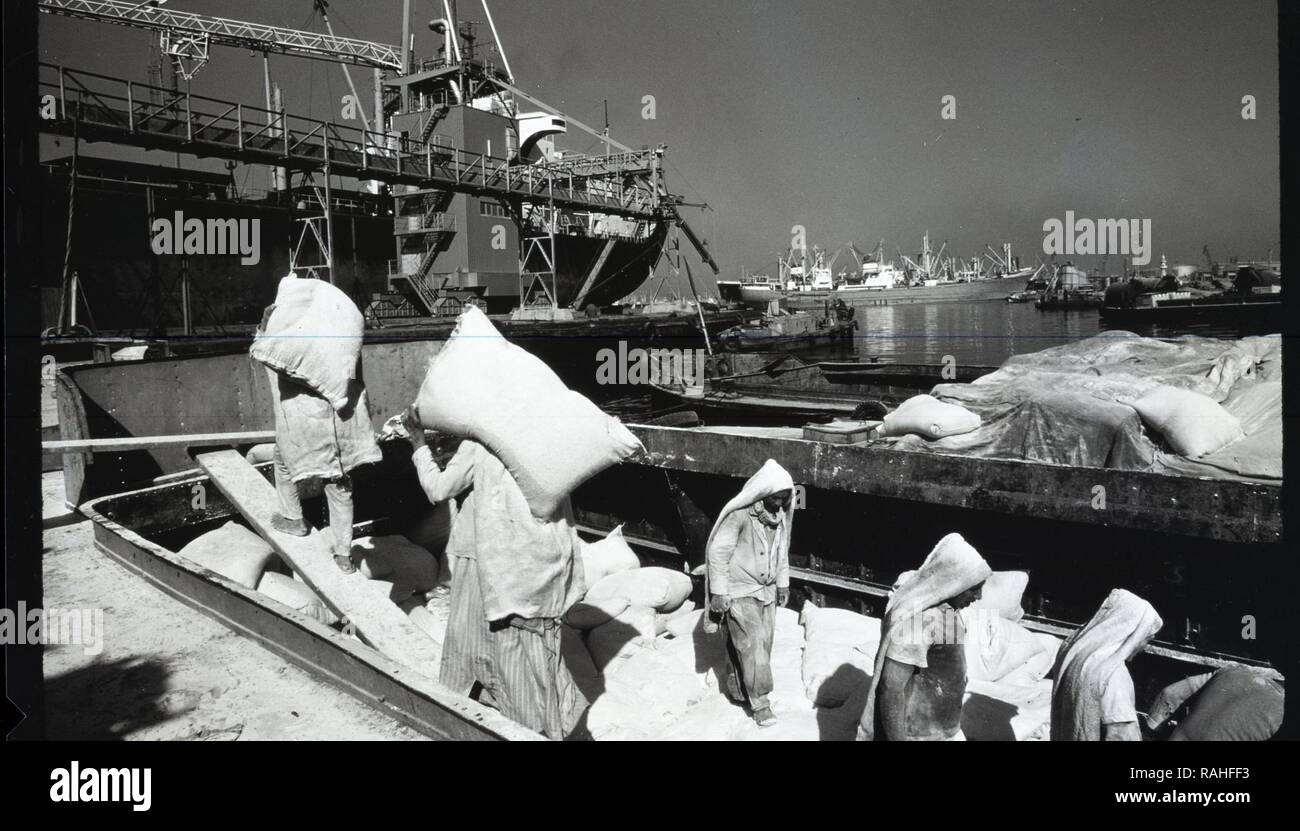A GROUP OF MEN MOVING PRODUCT FROM A SHIP Stock Photo - Alamy