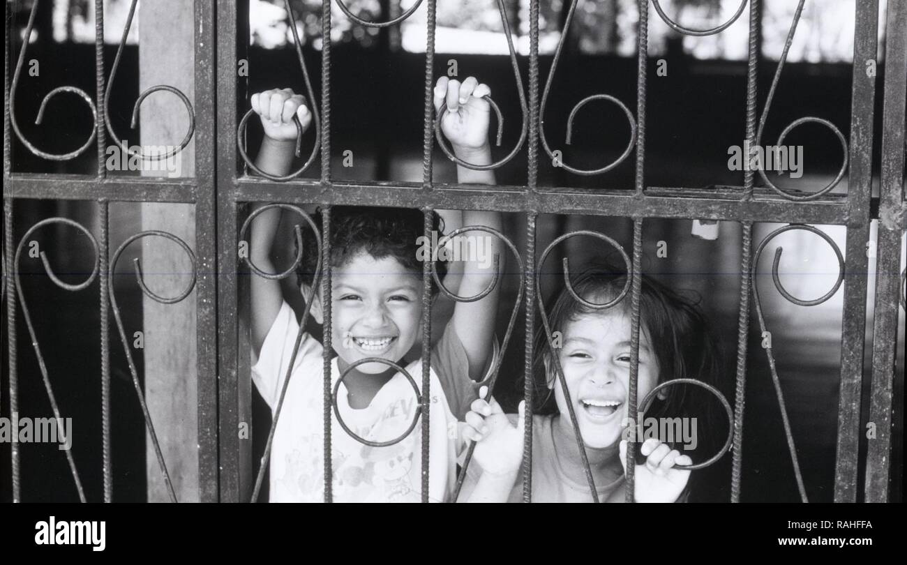 TWO CHILDREN BEHIND A GATE SMILING Stock Photo - Alamy