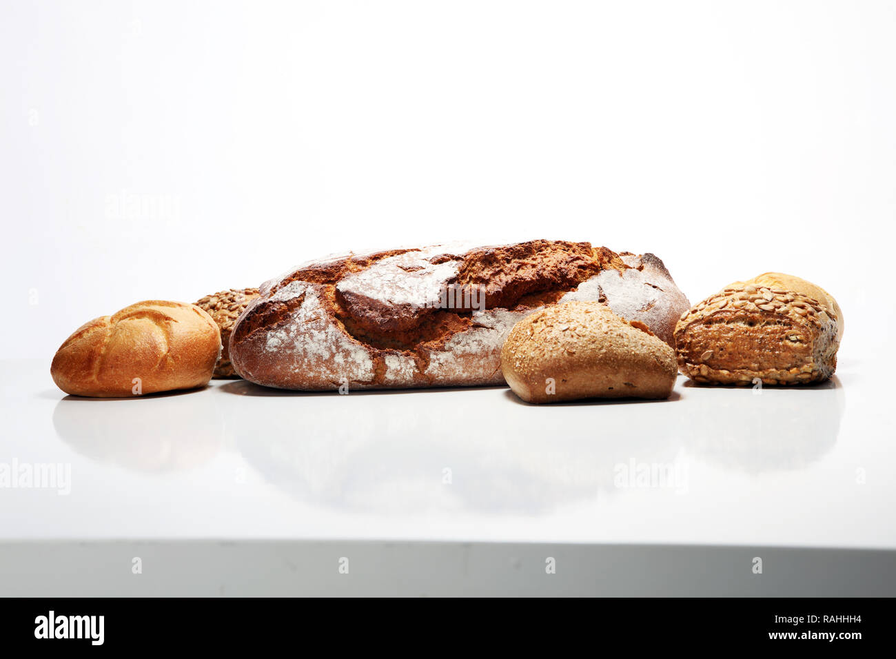 Different kinds of bread and bread rolls on board from above. Kitchen ...