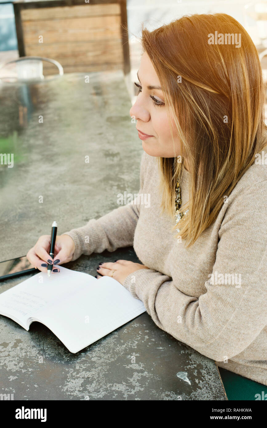 View of a young female woman looking and pondering what to write in her ...