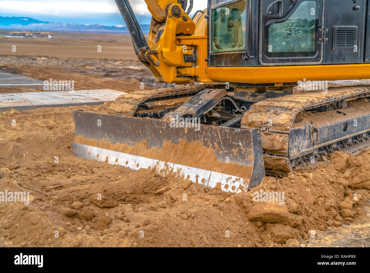 Excavator with dirt moving piece in front of tread Stock Photo - Alamy