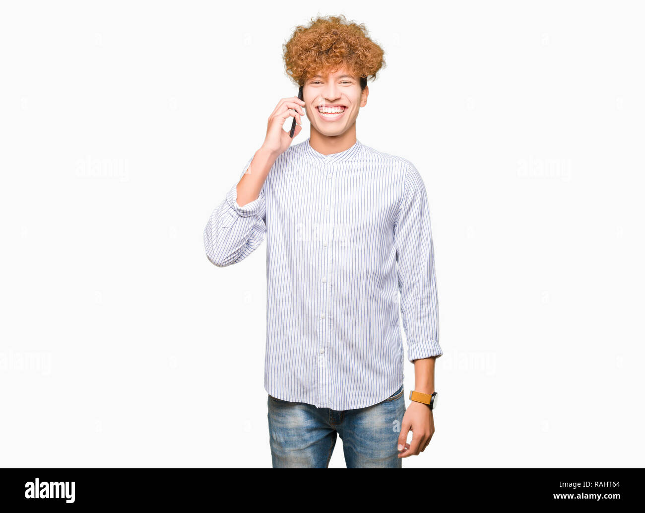 Young handsome man talking on the phone with a happy face standing and ...