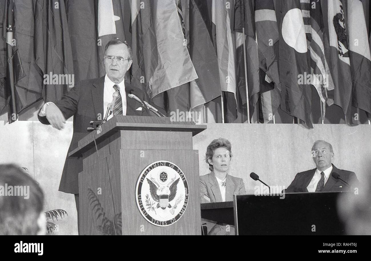 BUSH IS AT THE PODIUM TALKING WITH A MAN AND WOMEN WATCHING Stock Photo ...